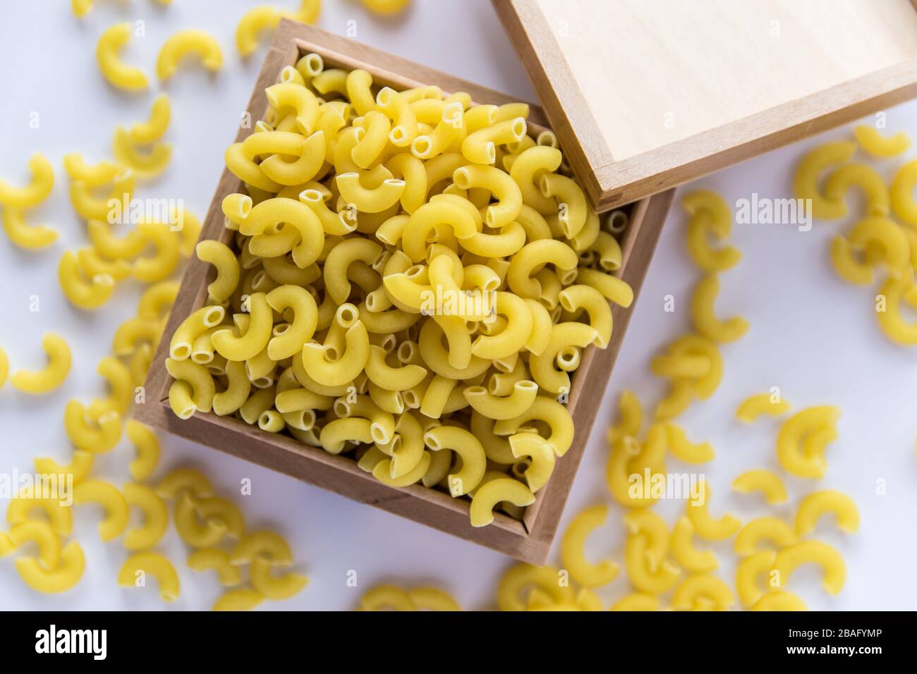 Italian food concept and menu design. Uncooked yellow pasta in wood box ...