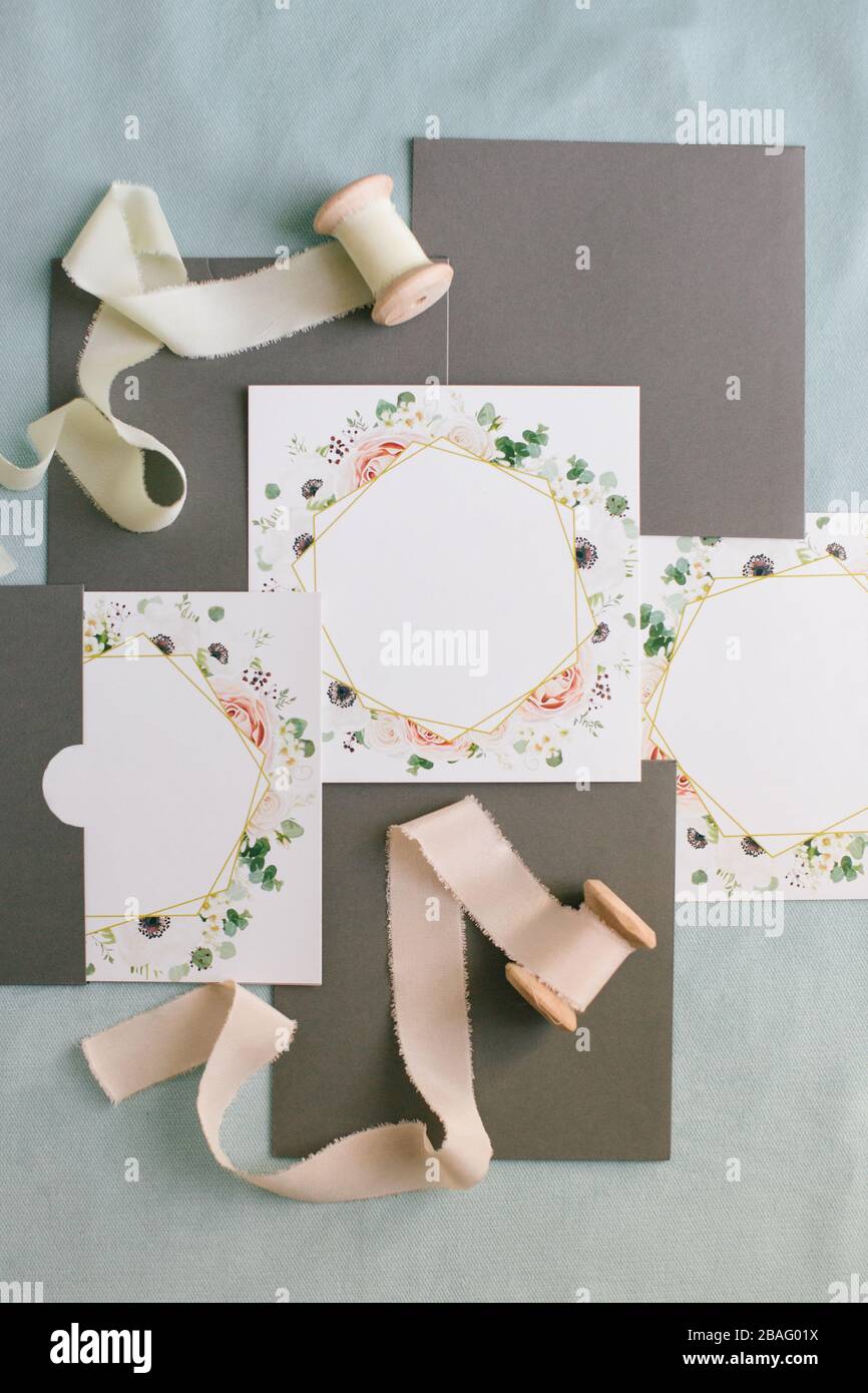 Wedding invitation on blue backdrop. Silk fabric rolls, diamond rings ...