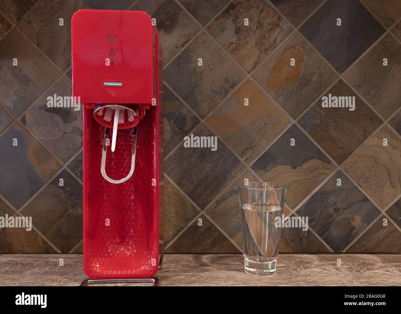 Red Sodastream with Glass of Water in Kitchen with Tile Background ...