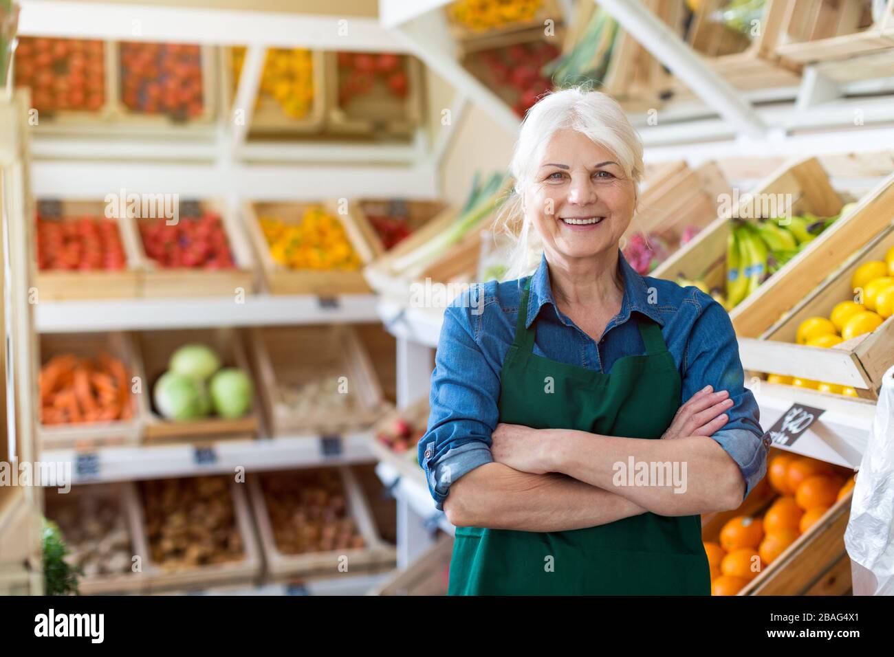 Senior woman working in small grocery store Stock Photo - Alamy
