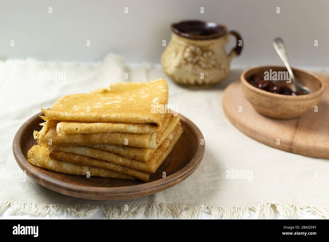 Pancakes (Russian Blini) with strawberry jam and tea in a rustic style ...