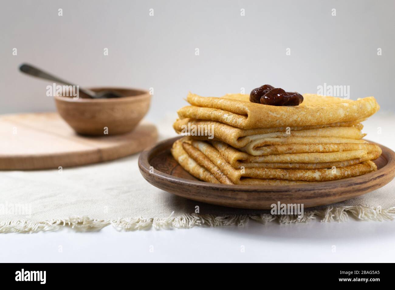 Pancakes (Russian Blini) with strawberry jam and tea in a rustic style ...