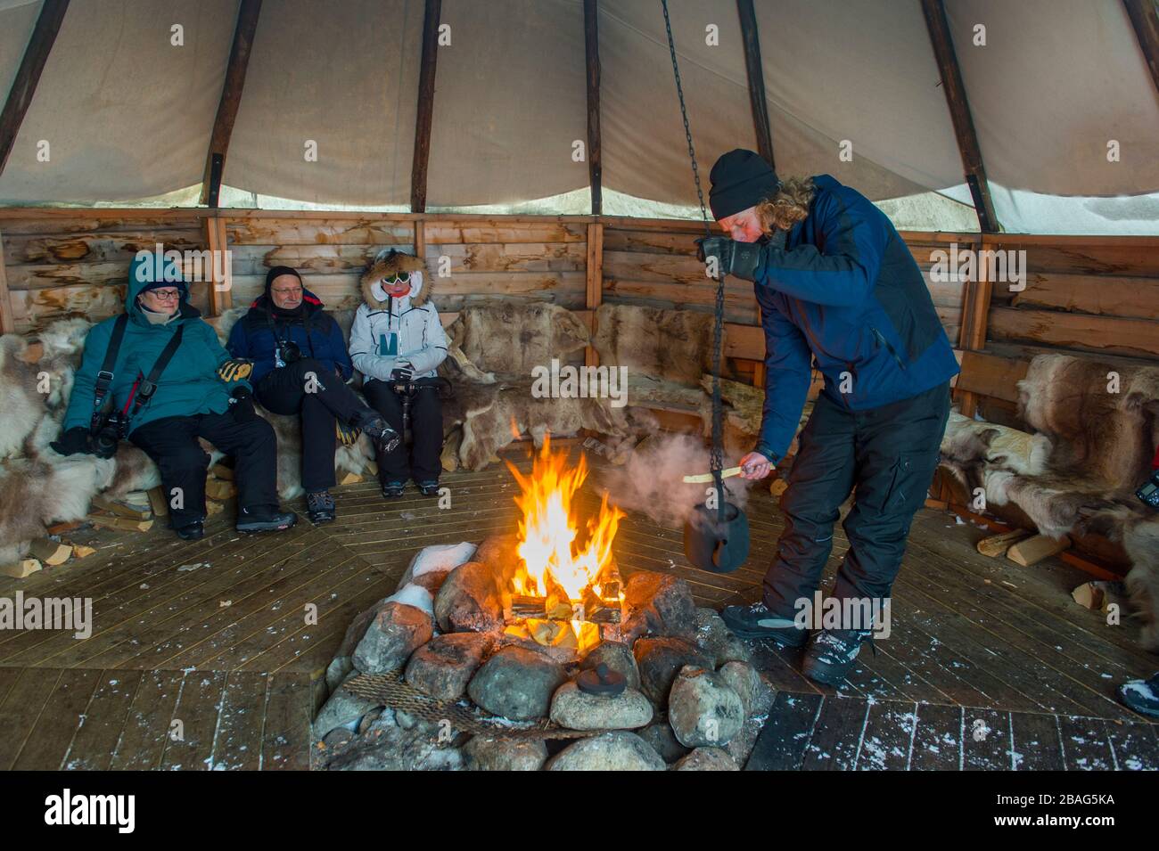 Tourists inside a Lavvu, a tent which is a temporary dwelling used by ...