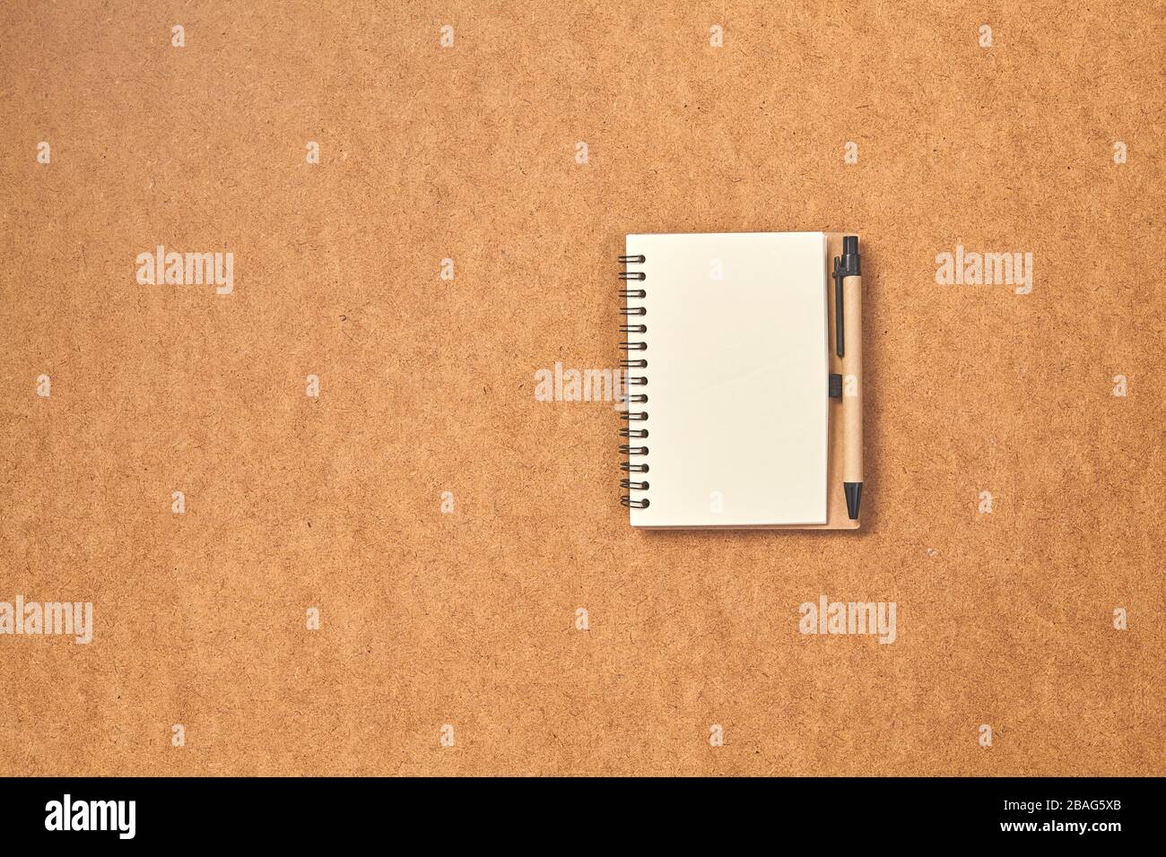 Top view spiral notebook with penc on brown desk background. Copy space ...