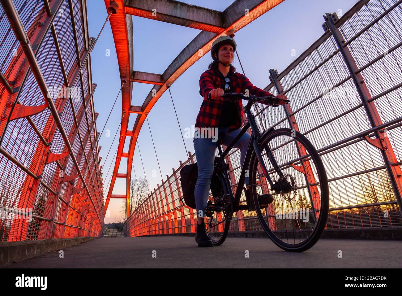 Caucasian Woman Riding a Bicycle on a Pedestrian Bridge over the ...
