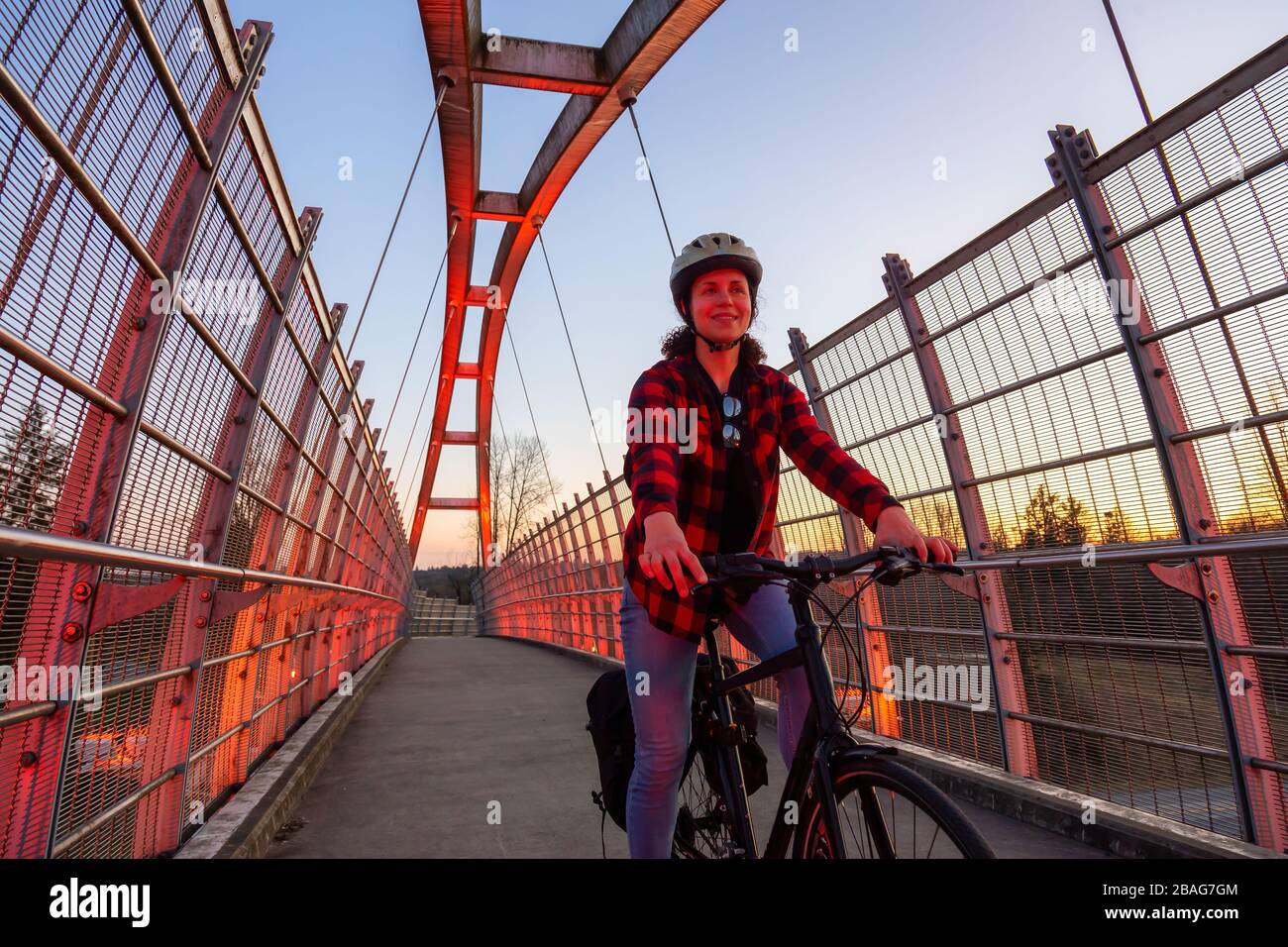 Caucasian Woman Riding a Bicycle on a Pedestrian Bridge over the ...