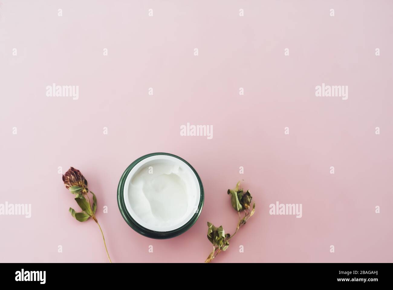 Jar of moisturizer on a pink background with copy space. The concept of ...