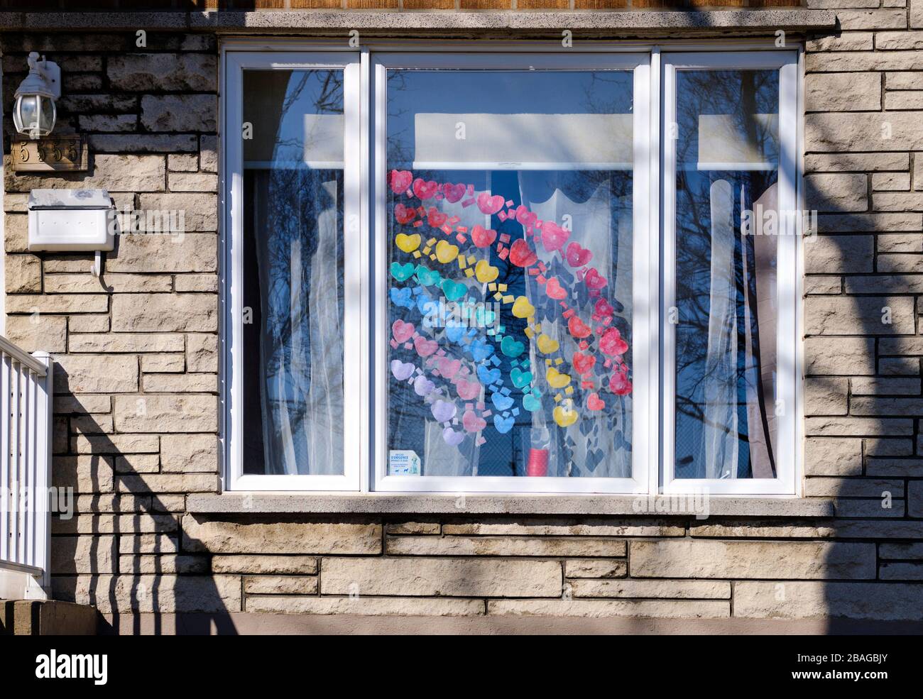 House window with rainbow made of hearts as message of hope in Montreal ...
