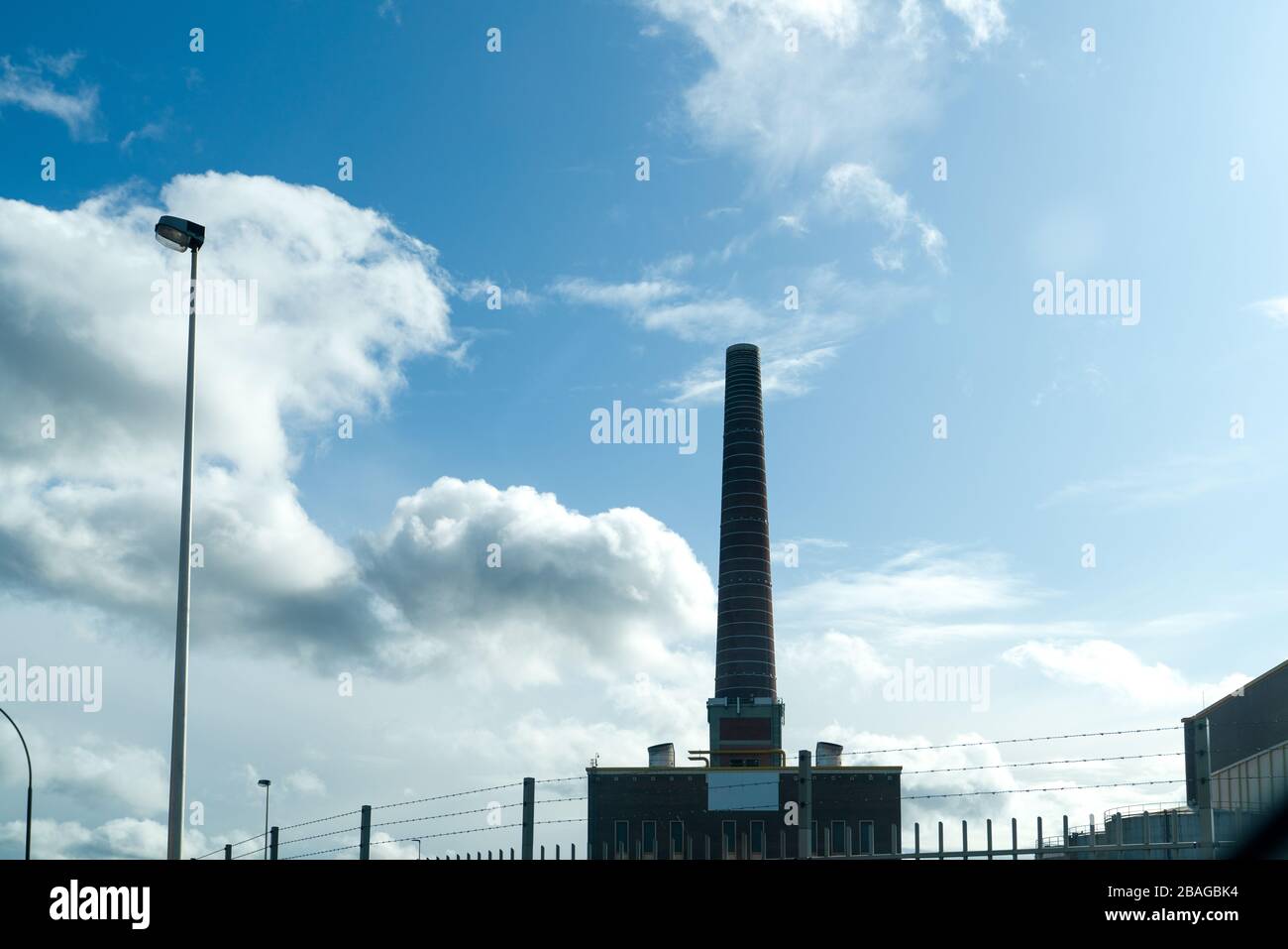 Old factory chimney on blue sky background Stock Photo - Alamy