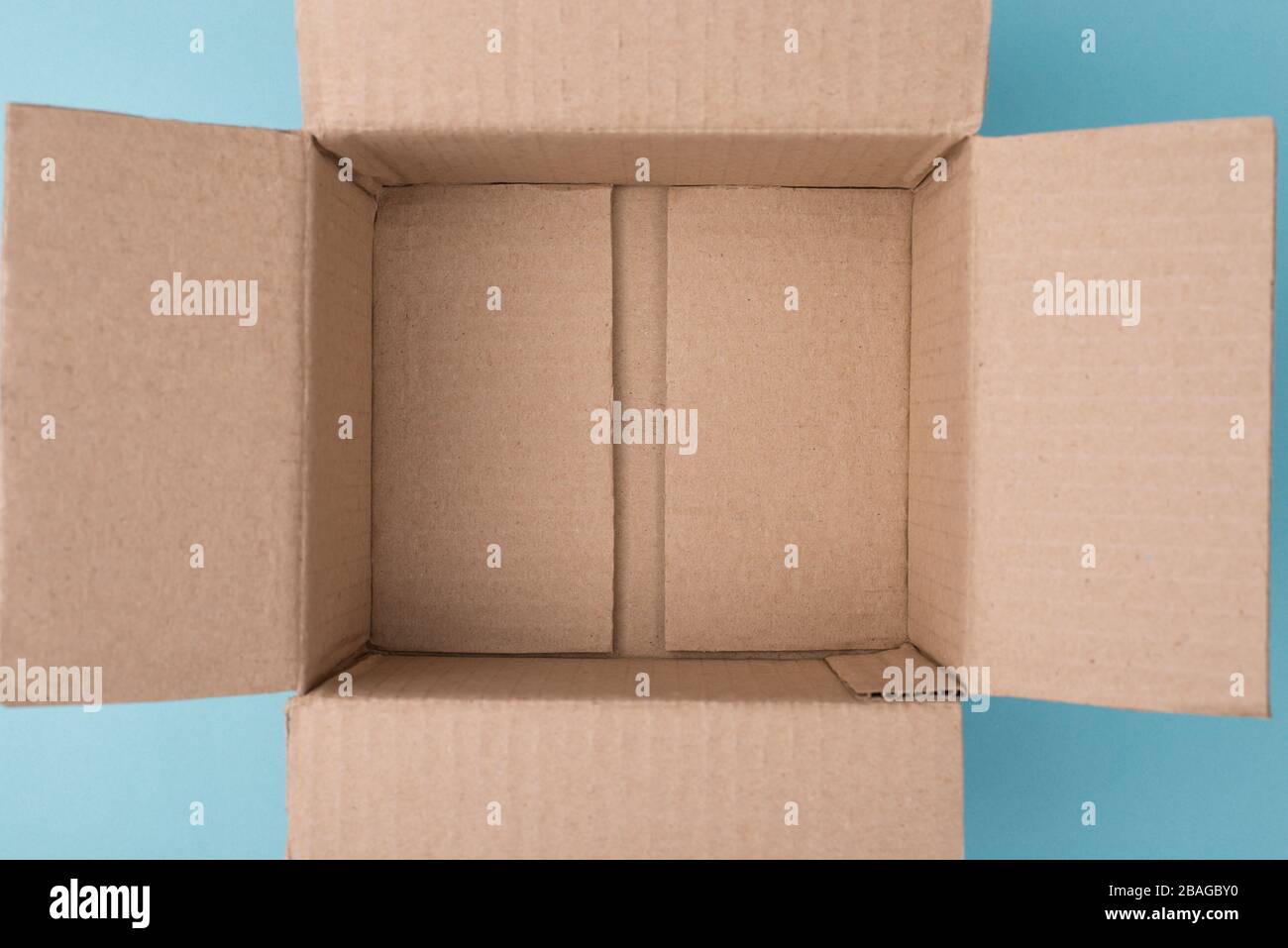 Top overhead above closeup view photo of unpacked empty box on blue ...