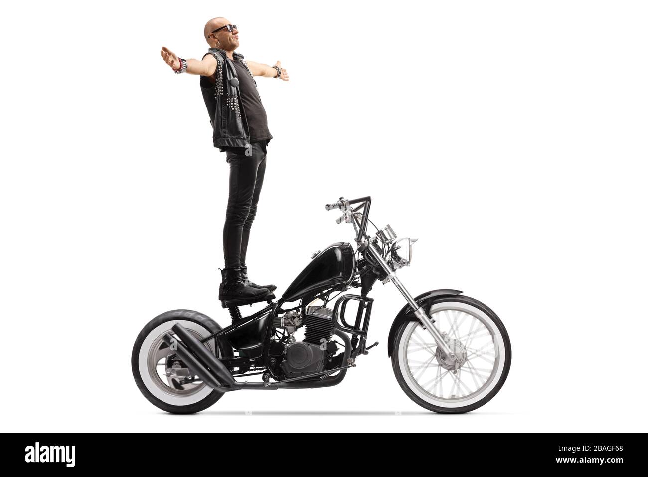 Bald punk daredevil man standing on a chopper motorbike isolated on ...