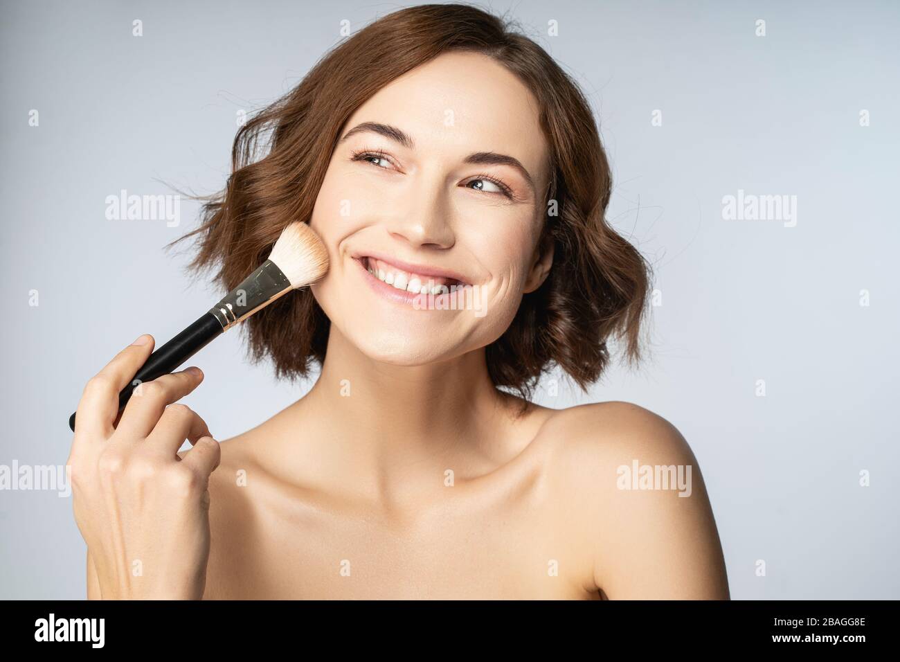 Positive delighted young female doing daily makeup Stock Photo - Alamy
