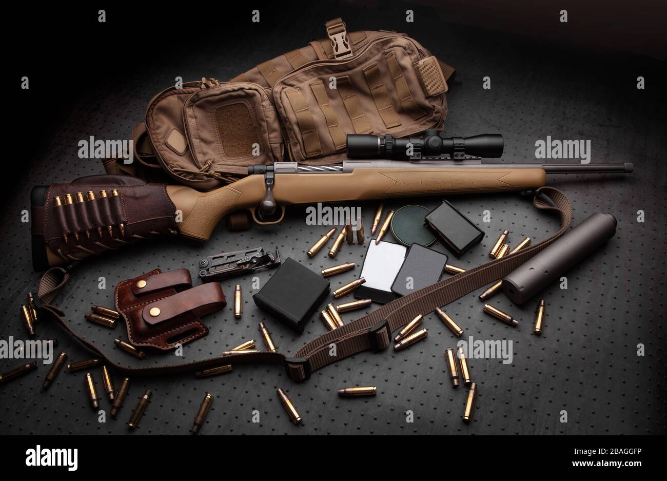 Modern bolted carbine and cartridges for it on a dark wooden table ...