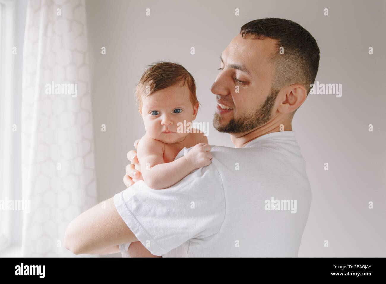 Happy Caucasian father holding newborn baby. Male bearded man parent ...