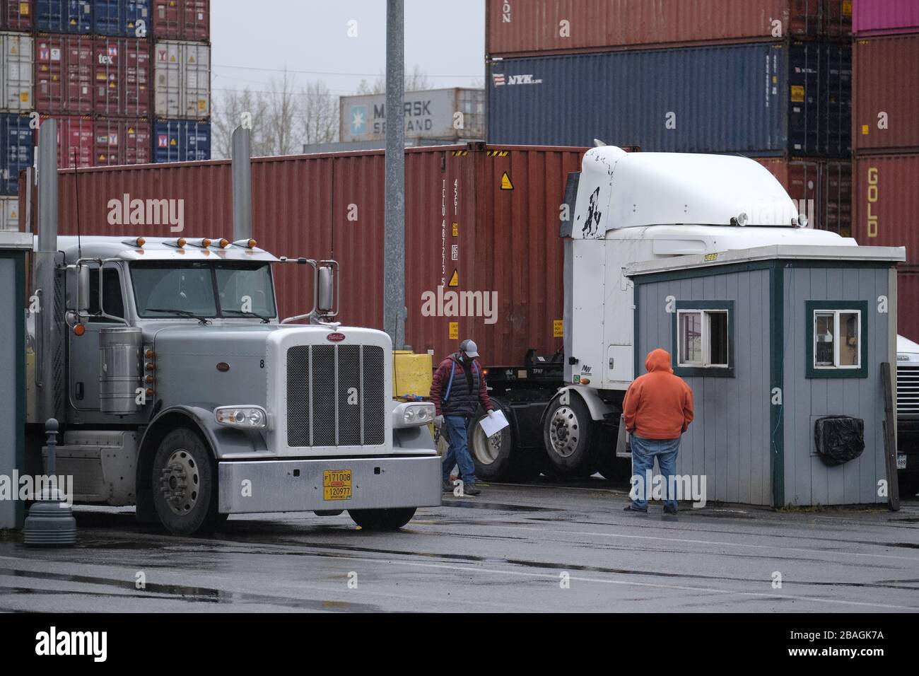 Portland, USA. 27th Mar, 2020. Truck drivers check their cargo into the ...