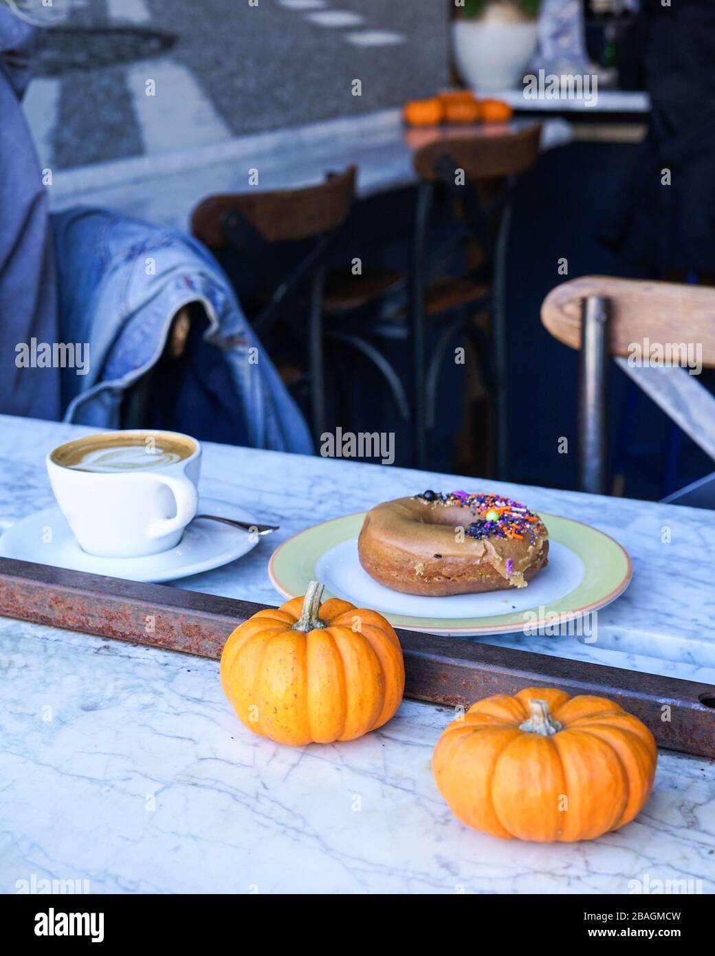 Morning cafe essentials with a coffee and donut Stock Photo - Alamy