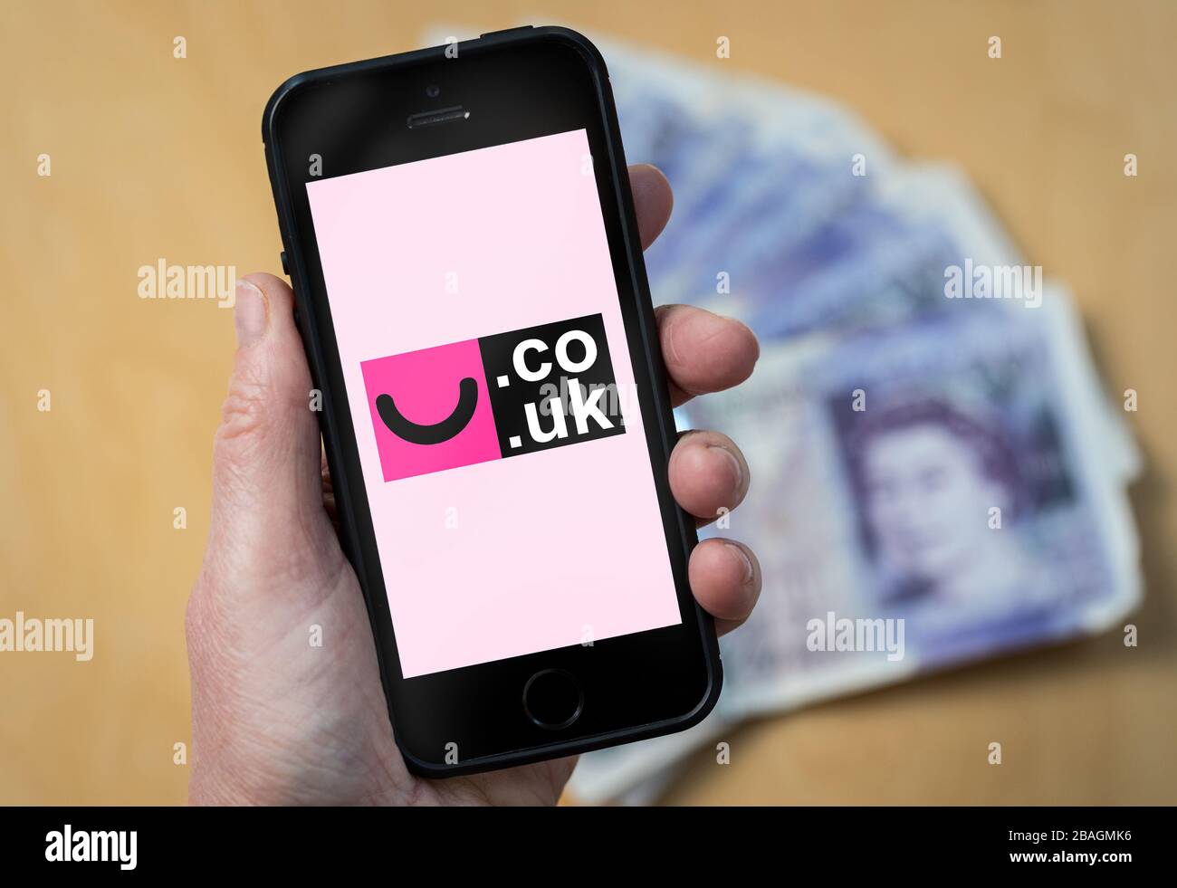 A woman looking at the Smile Bank logo on a mobile phone. (editorial ...