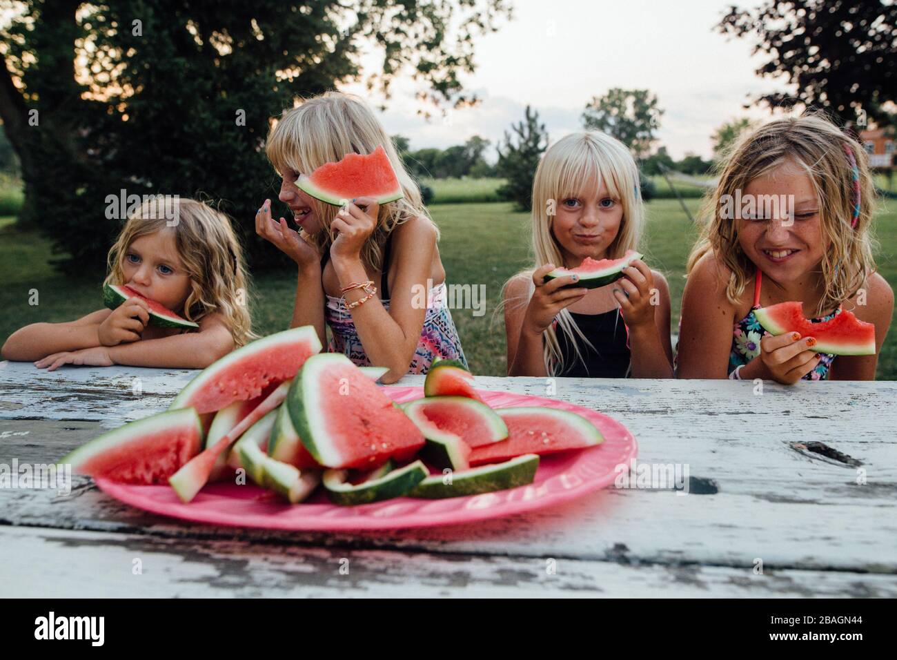 Siblings having fun eating watermelon outside in summertime Stock Photo ...