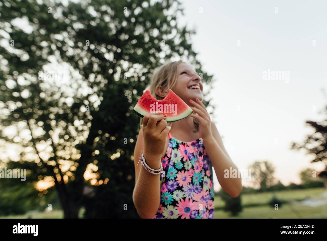 Young girl with big smile eating watermelon during the summer outside ...