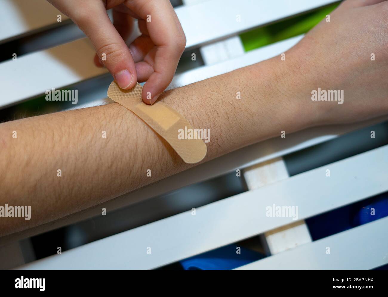 Hand putting band-aid on a wound on the arm. Band aid concept Stock ...