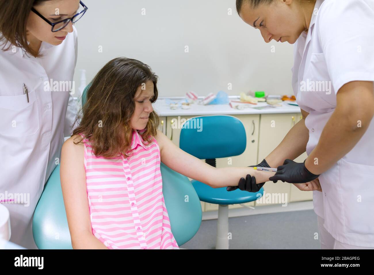 Dentist makes an injection in hand, checks reaction of body to ...