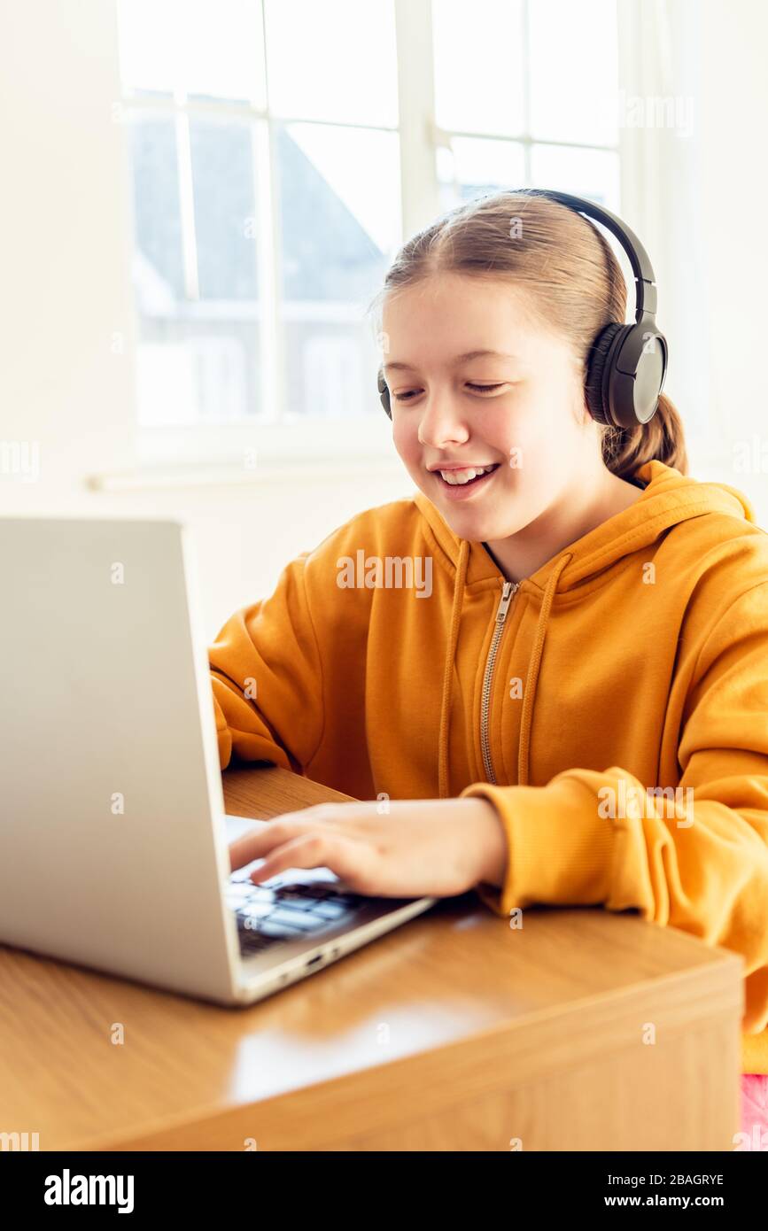 School age girl is home schooling using laptop during self isolation at ...