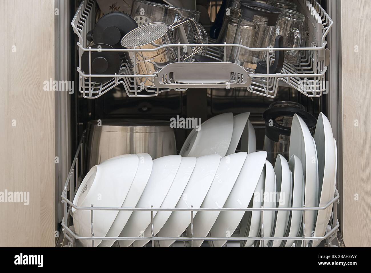 Full loaded Dishwasher machine. Integrated Dishwasher with white plates ...