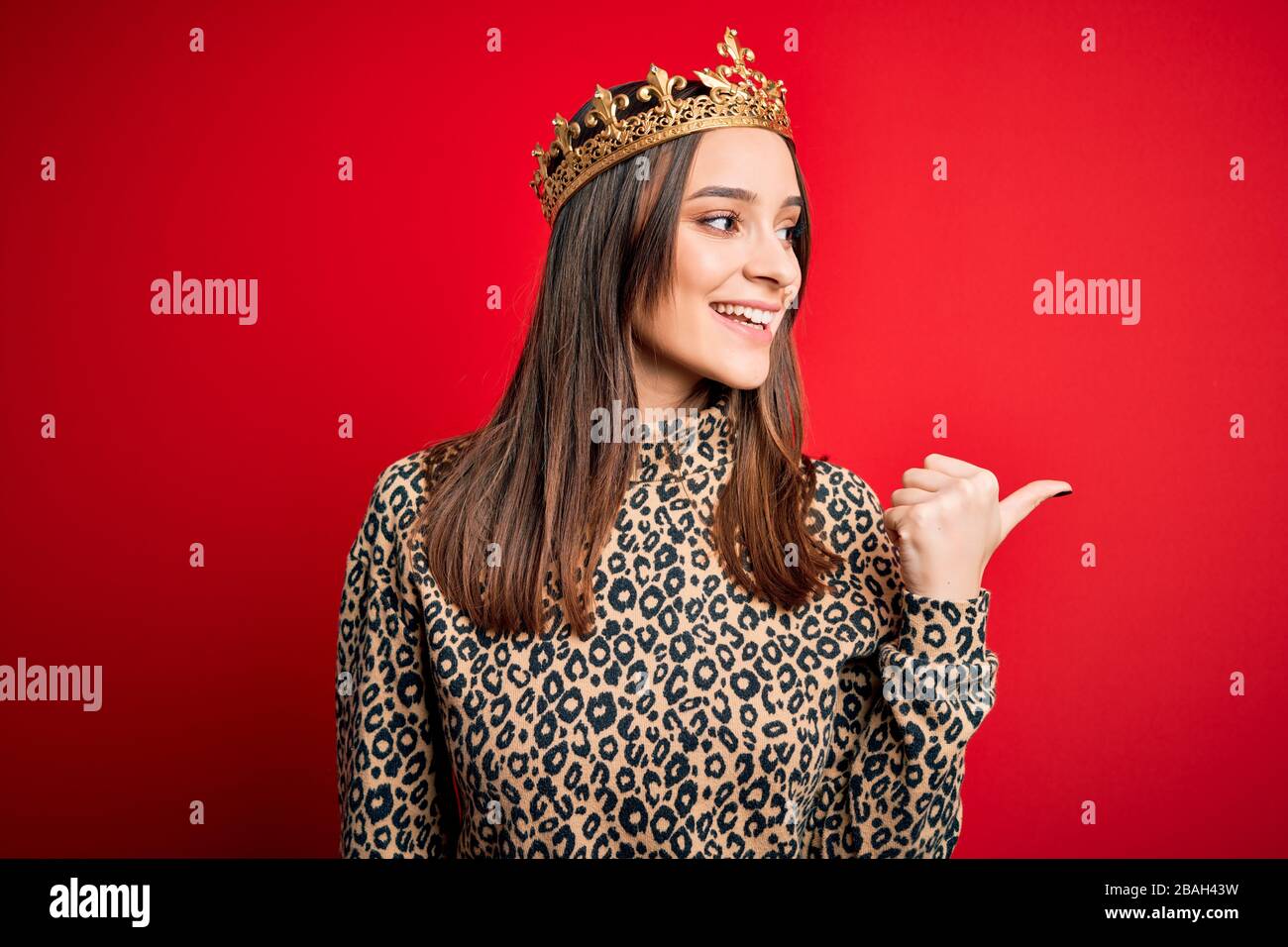 Young beautiful brunette woman wearing golden crown queen over isolated ...