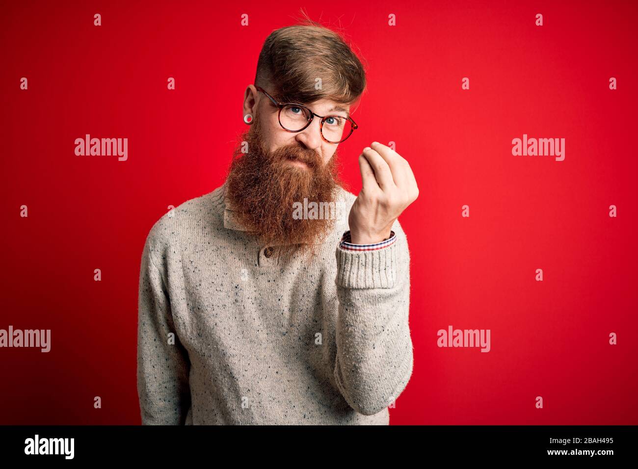 Handsome Irish redhead man with beard wearing casual sweater and ...