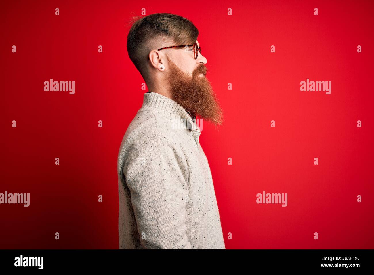 Handsome Irish redhead man with beard wearing casual sweater and ...