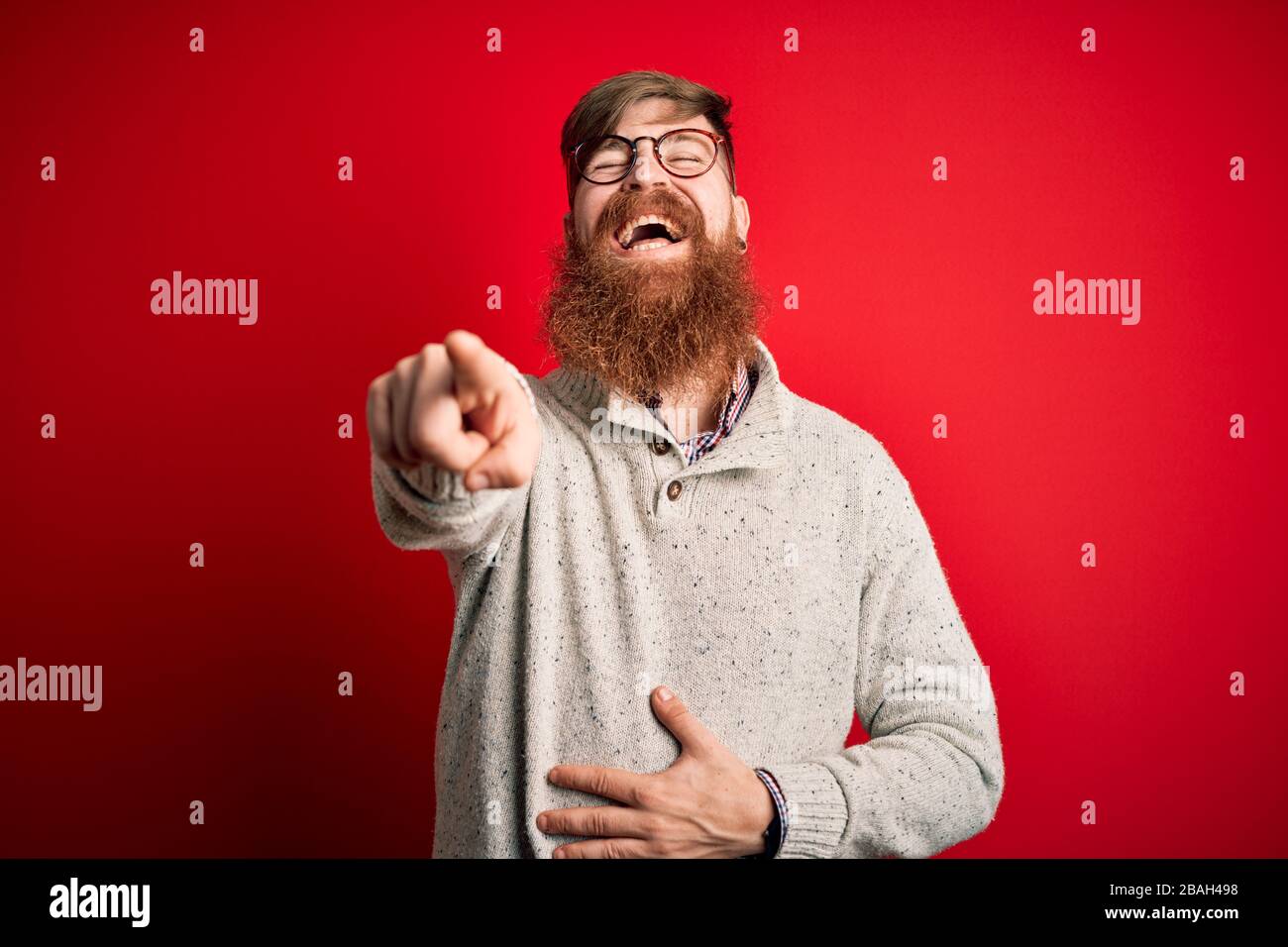 Handsome Irish redhead man with beard wearing casual sweater and ...