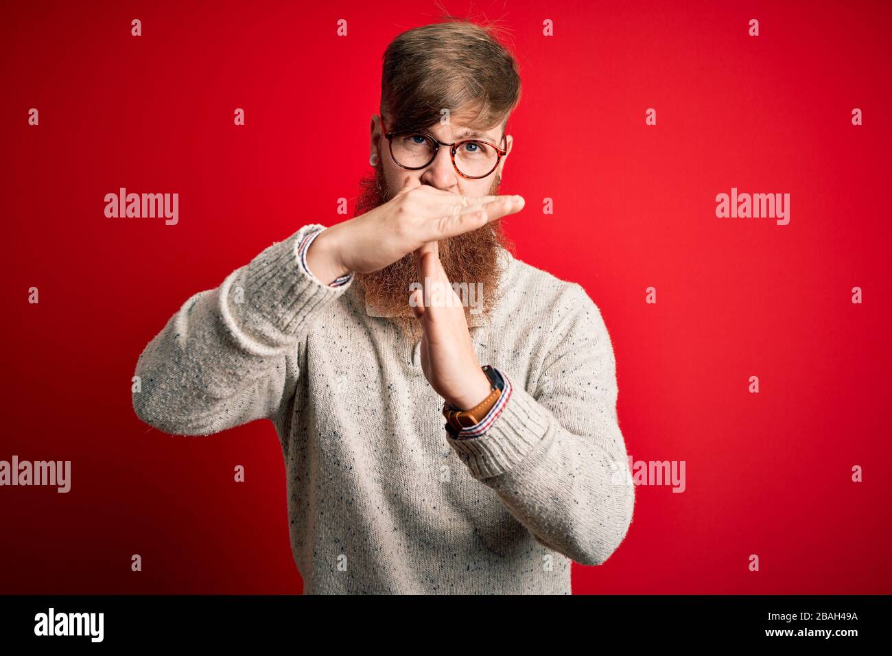 Handsome Irish redhead man with beard wearing casual sweater and ...
