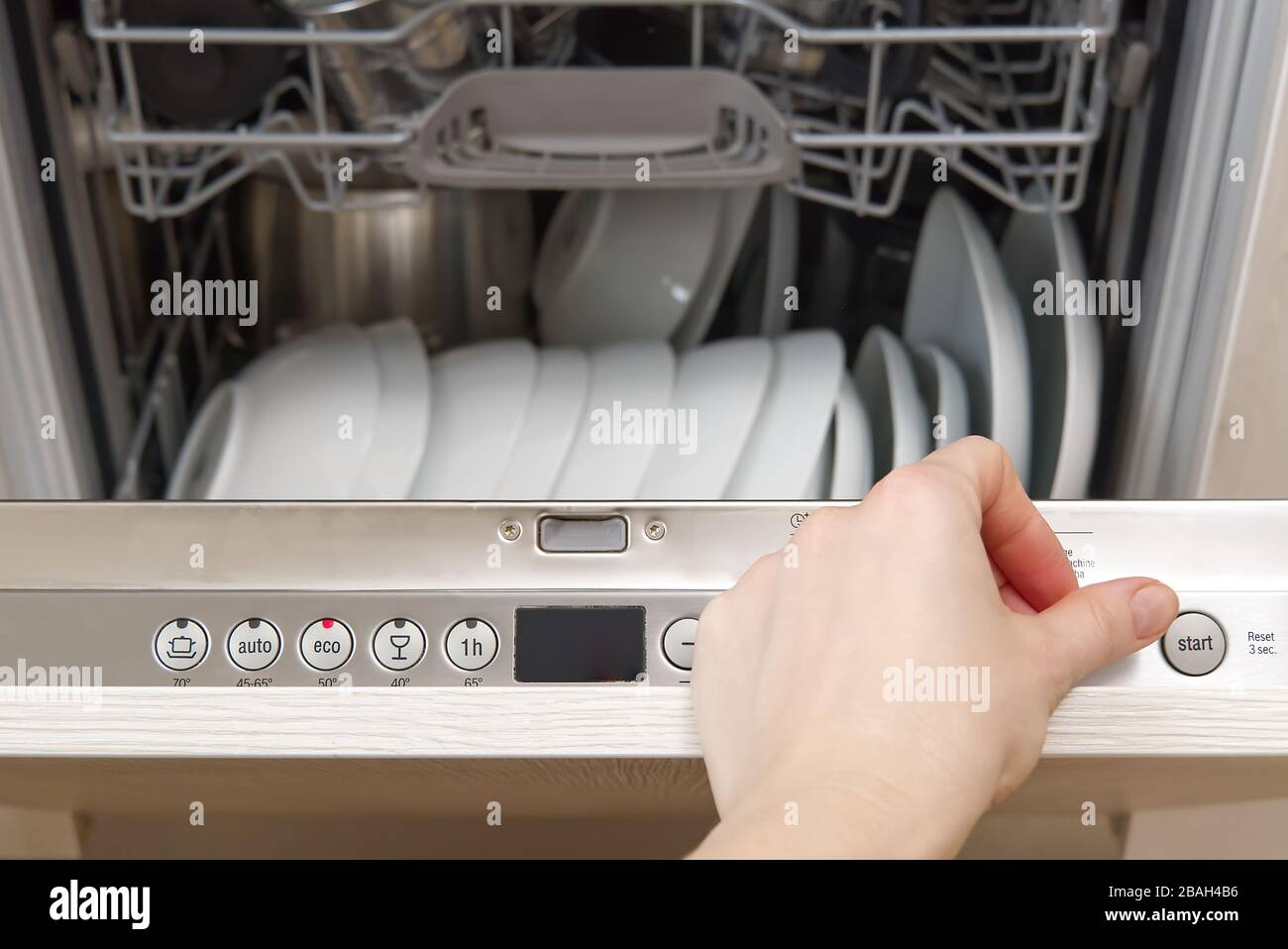 Full loaded Dishwasher machine. Dishwasher with white plates front vew ...