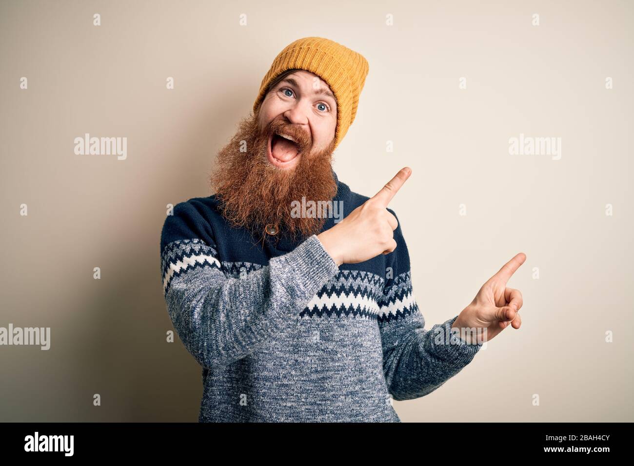 Handsome Irish redhead man with beard wearing winter sweater and wool ...