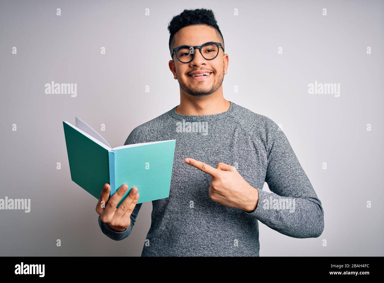 Young handsome smart student man reading book over isolated white ...