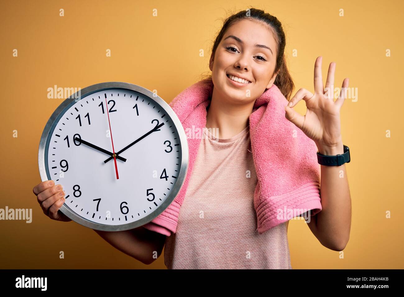 Young beautiful brunette sportswoman wearing towel doing countdown ...