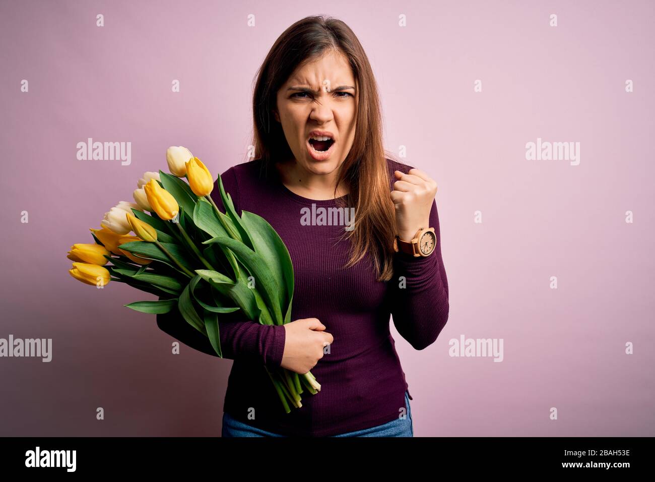 Young blonde woman holding romantic bouquet of yellow tulips flowers ...