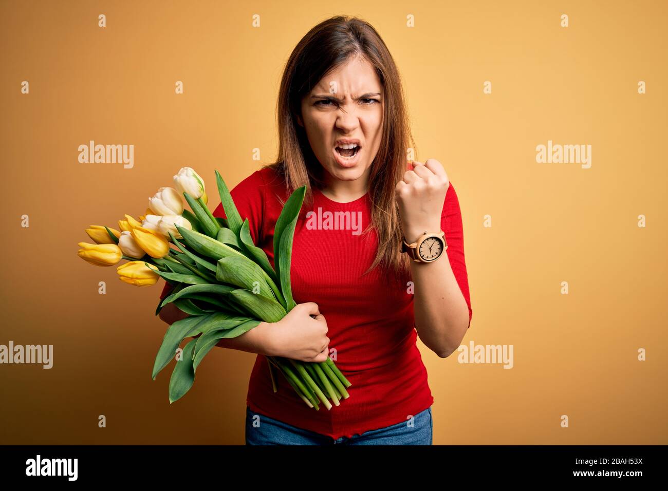 Young blonde woman holding romantic bouquet of tulips flowers over ...