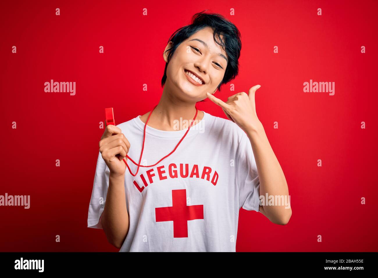 Young beautiful asian lifeguard girl wearing t-shirt with red cross ...