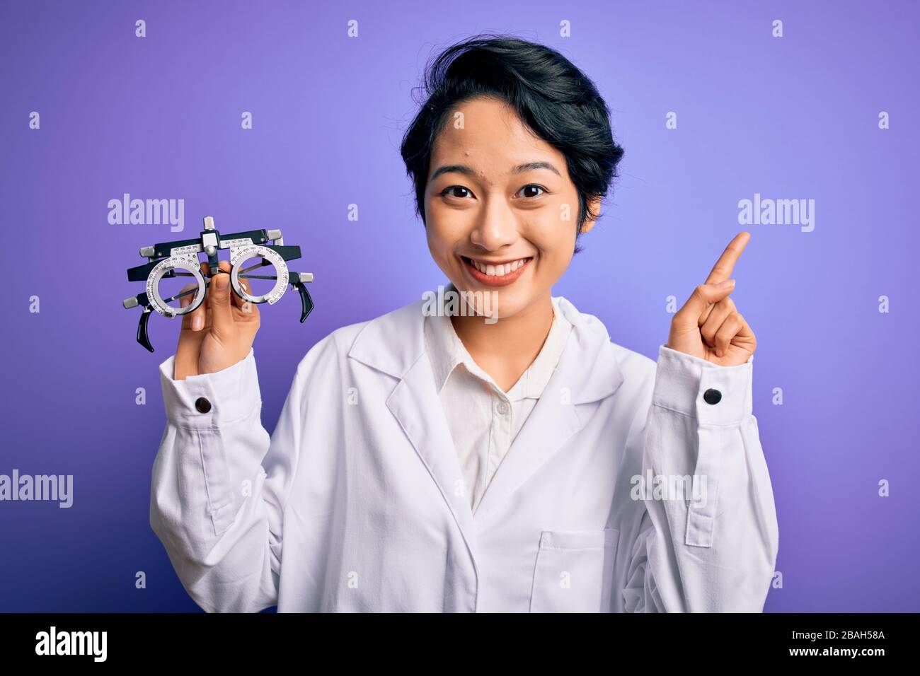 Beautiful asian optical girl wearing coat holding optometry glasses ...