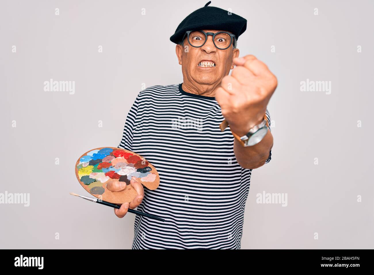 Senior hoary artist man wearing french beret drawing using paintbrush ...