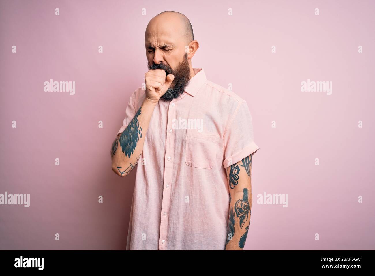 Handsome bald man with beard and tattoo wearing casual shirt over ...