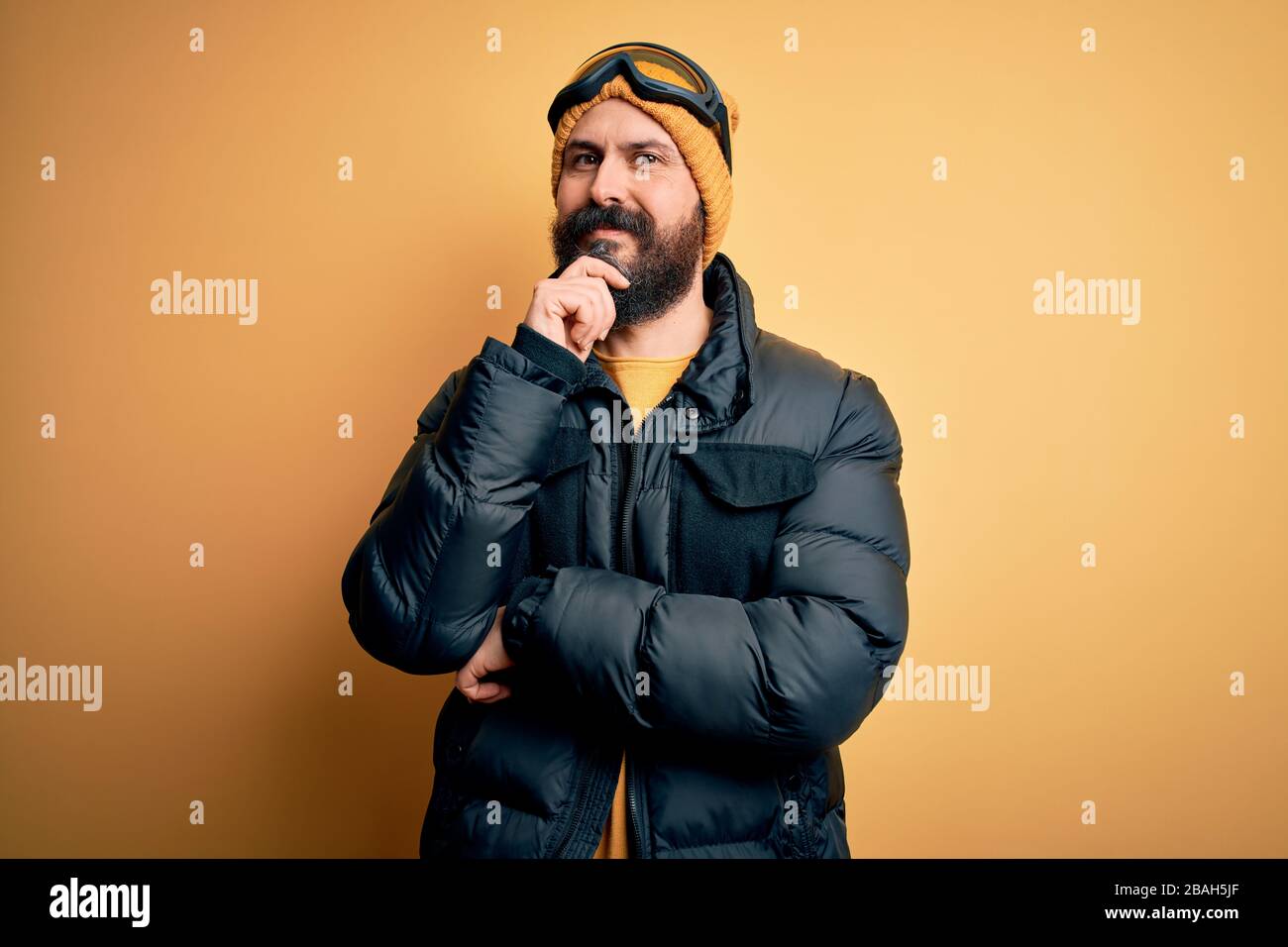 Handsome skier bald man with beard skiing wearing snow sportswear and ...