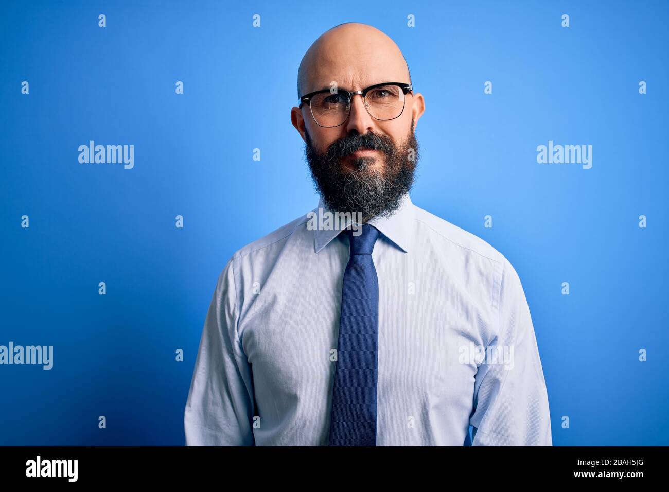 Handsome business bald man with beard wearing elegant tie and glasses ...
