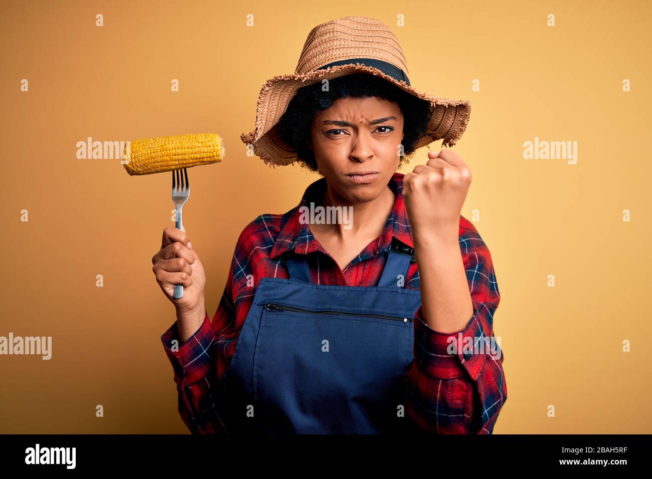 Young African American afro farmer woman with curly hair wearing apron ...