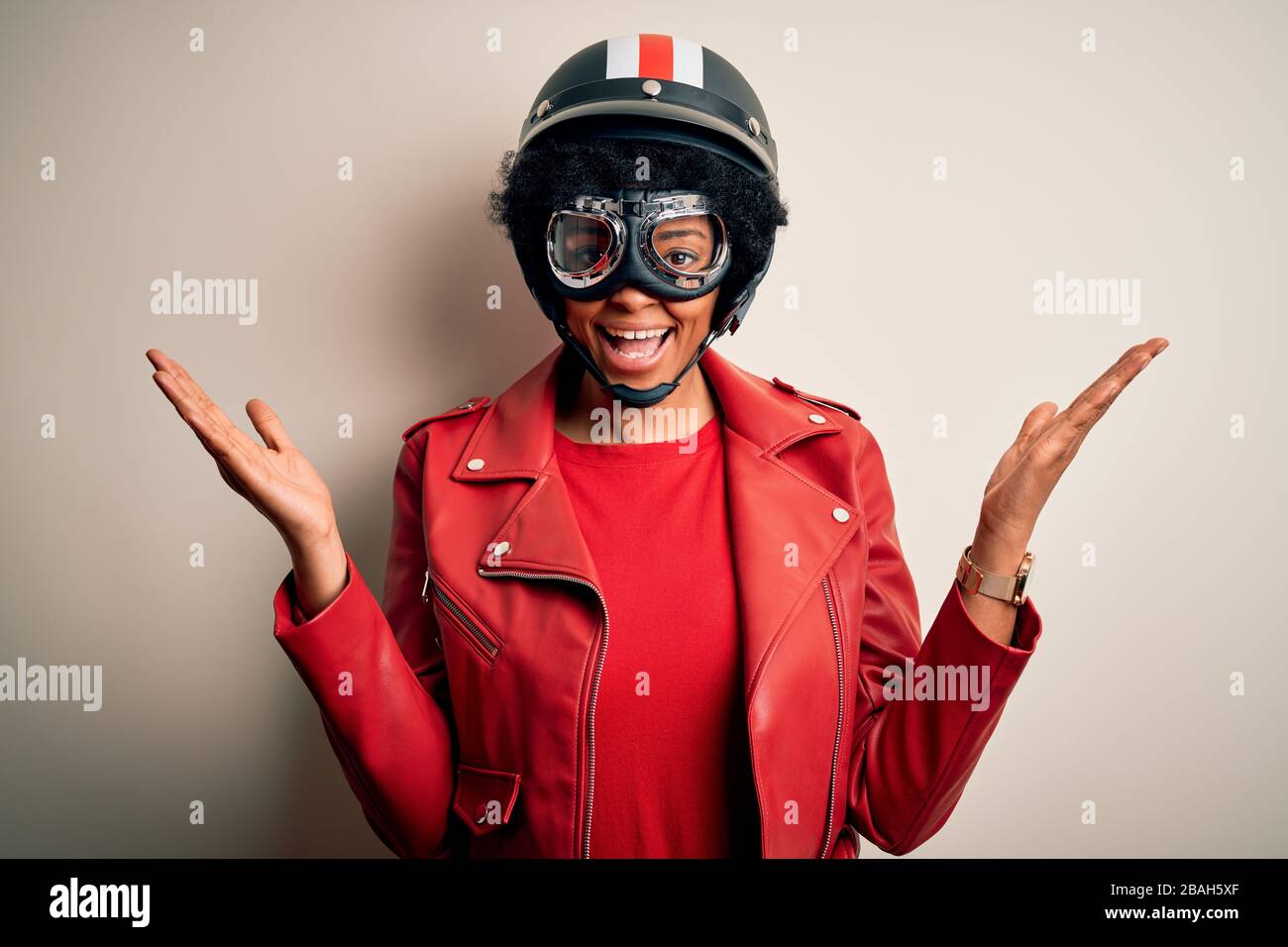 Young African American afro motorcyclist woman with curly hair wearing ...