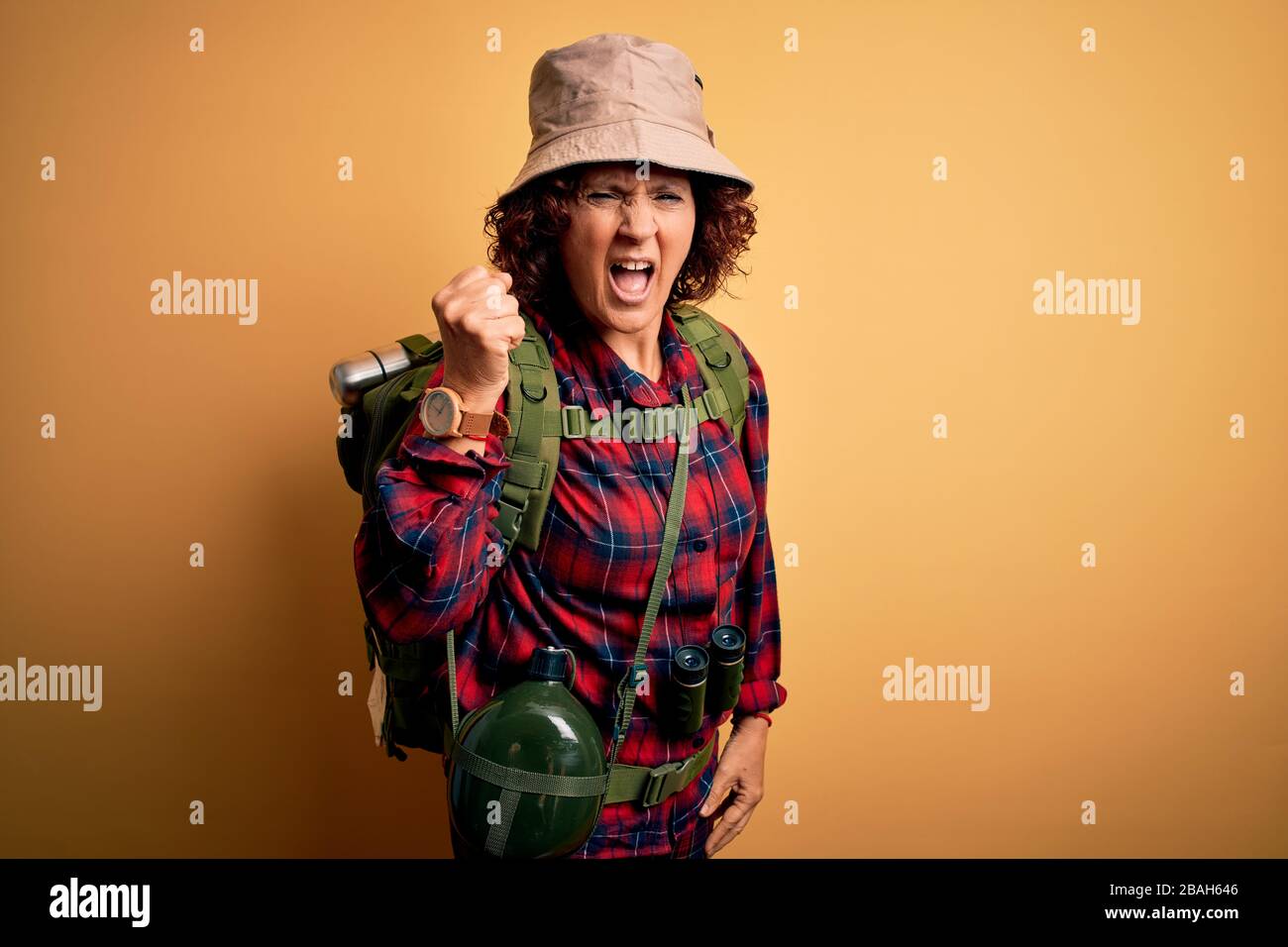 Middle age curly hair hiker woman hiking wearing backpack and water ...
