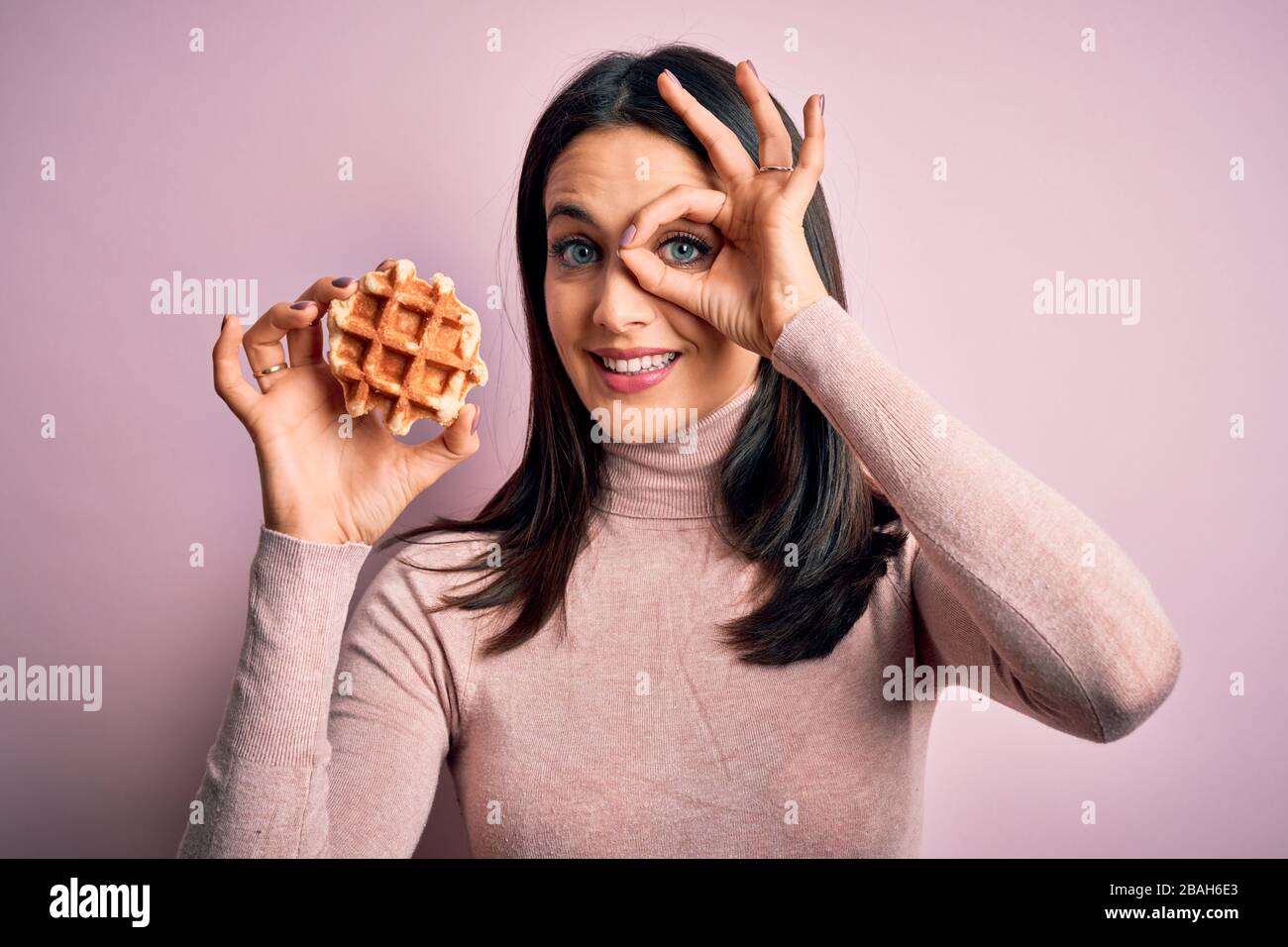 Young brunette woman with blue eyes eating sweet waffle for breakfast ...