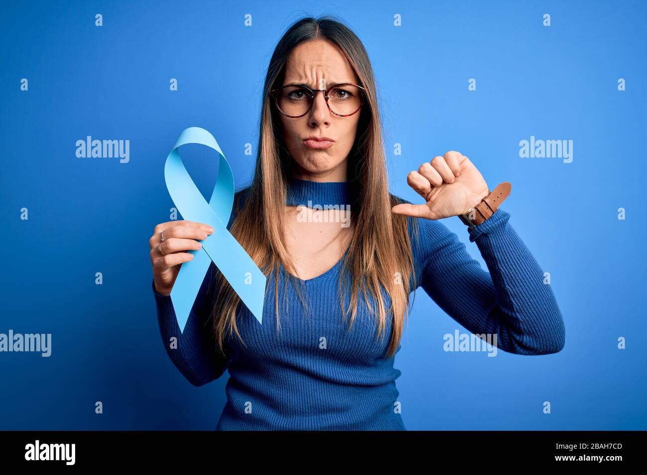 Young blonde woman with blue eyes holding colon cancer awareness blue ...