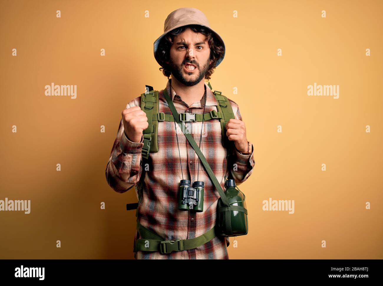 Young hiker man with curly hair and beard hiking wearing backpack and ...